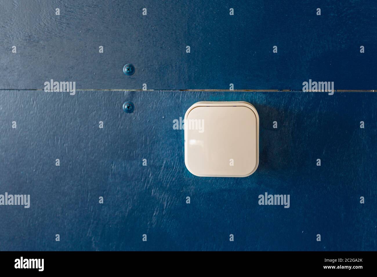 white plastic light switch on a blue wall Stock Photo - Alamy
