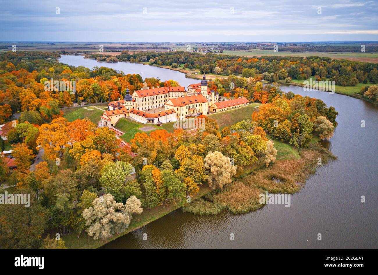 Autumn aerial view of Medieval castle in Nesvizh. Colorful maple park ...