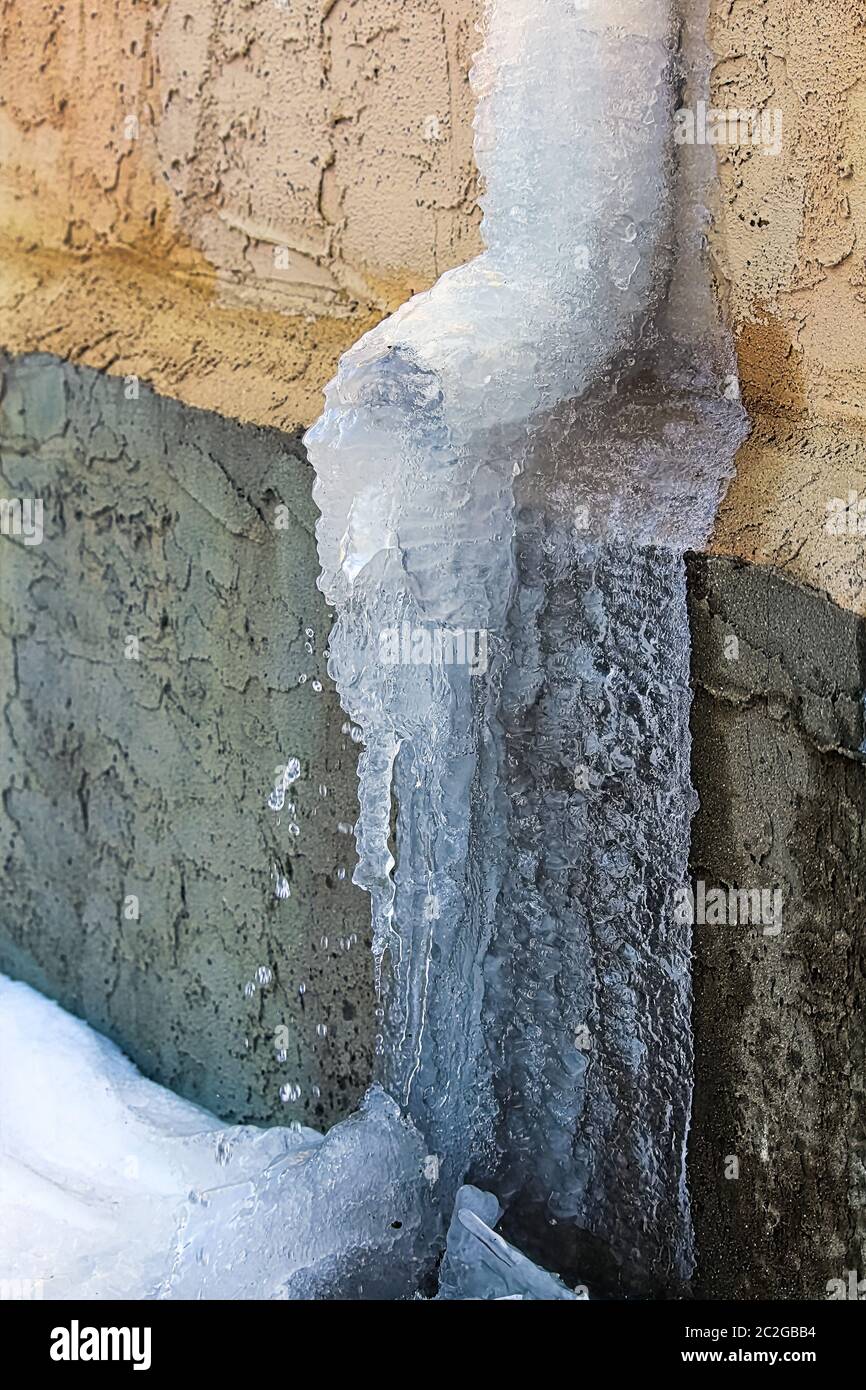 An eavestrough covered in ice and spring runoff water Stock Photo - Alamy