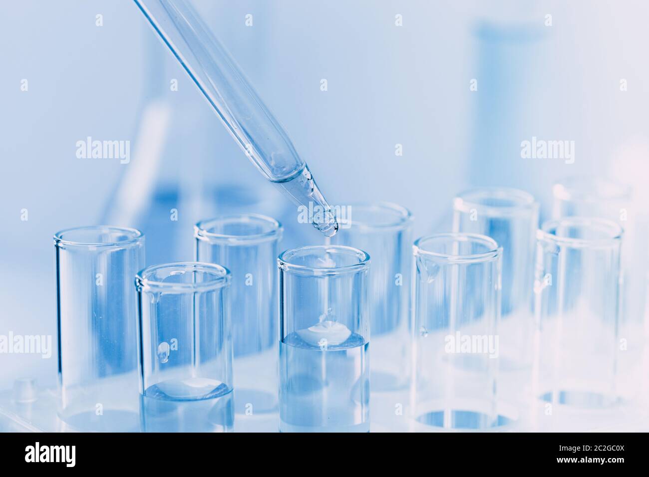 Laboratory glassware with a dropper dripping liquid into a test tube ...