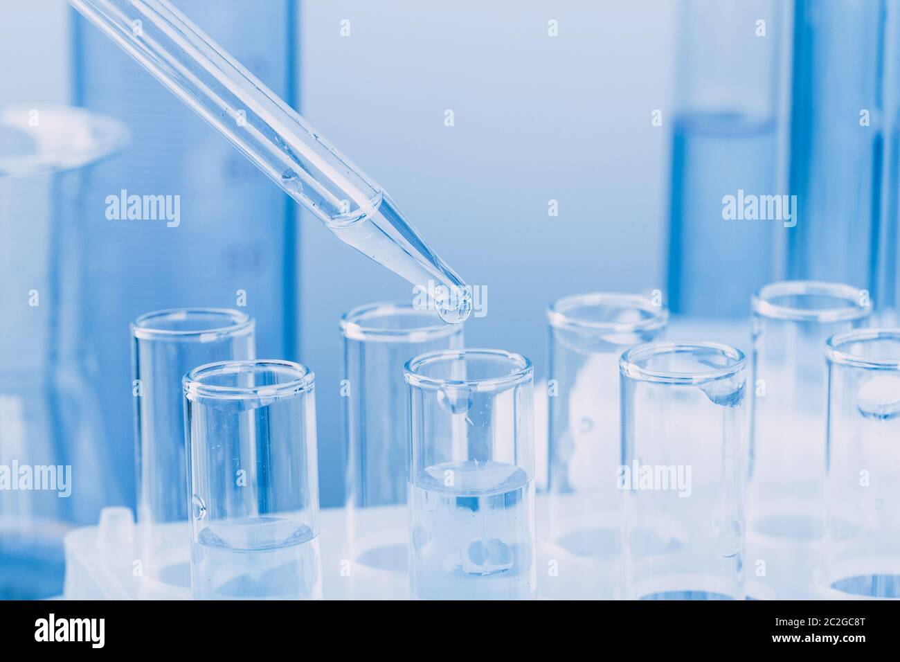 Laboratory glassware with a dropper dripping liquid into a test tube ...