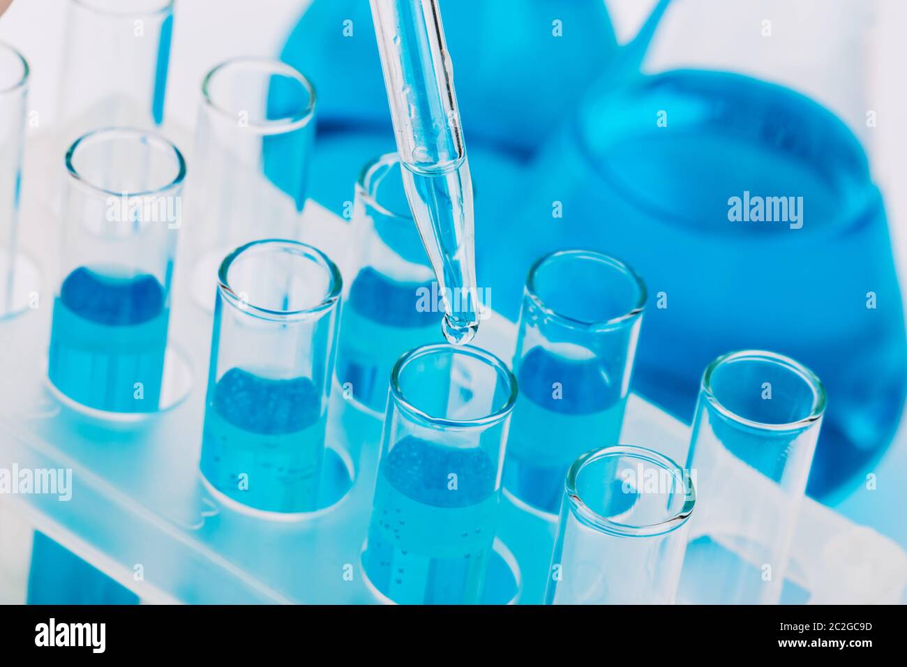 Laboratory glassware with a dropper dripping liquid into a test tube ...