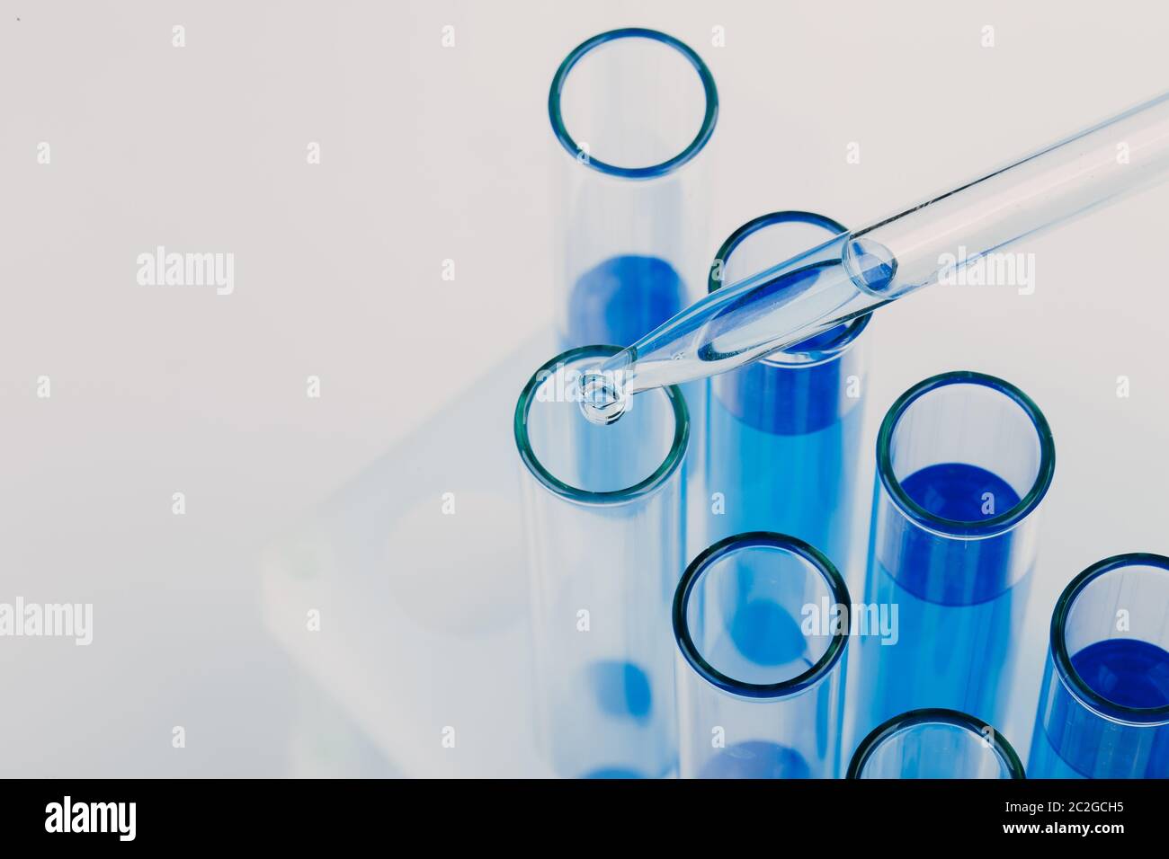 Laboratory glassware with a dropper dripping liquid into a test tube ...
