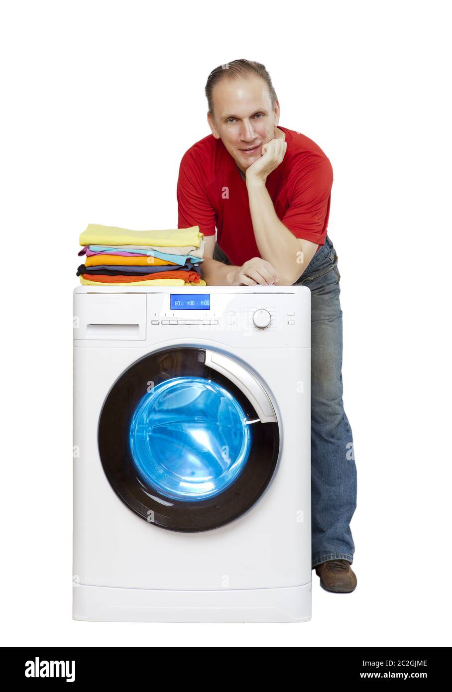 happy man smiling standing next to a new washing machine and a stack of ...