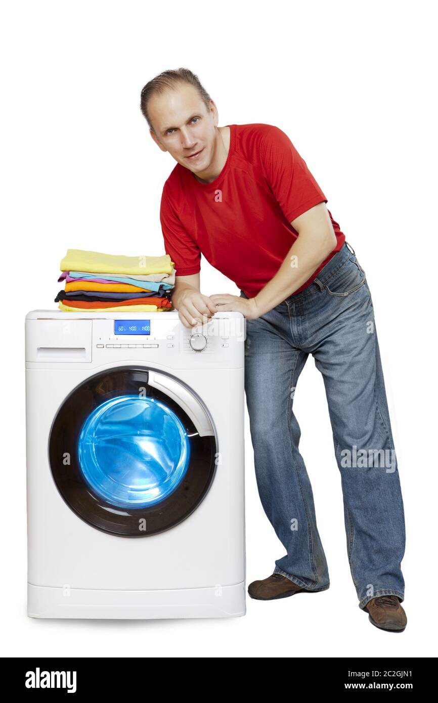 happy man smiling standing next to a new washing machine and a stack of ...