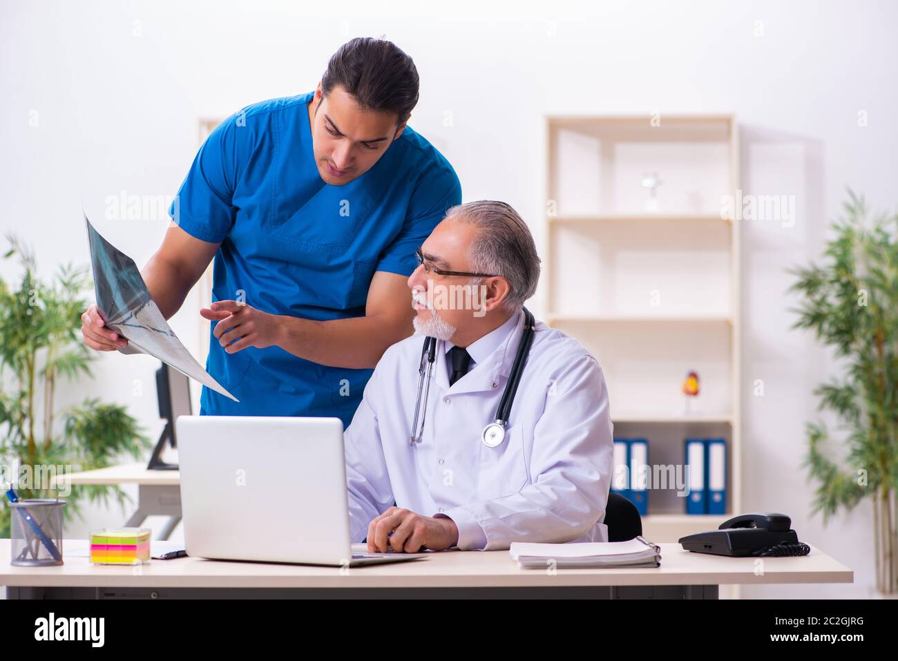 Two male doctors working in the modern clinic Stock Photo - Alamy