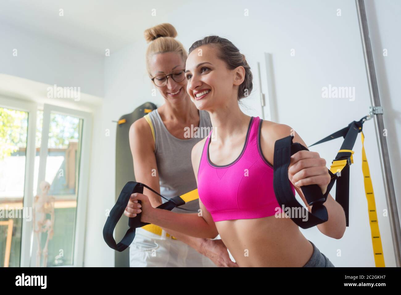 Woman using sling trainer during physical therapy Stock Photo - Alamy