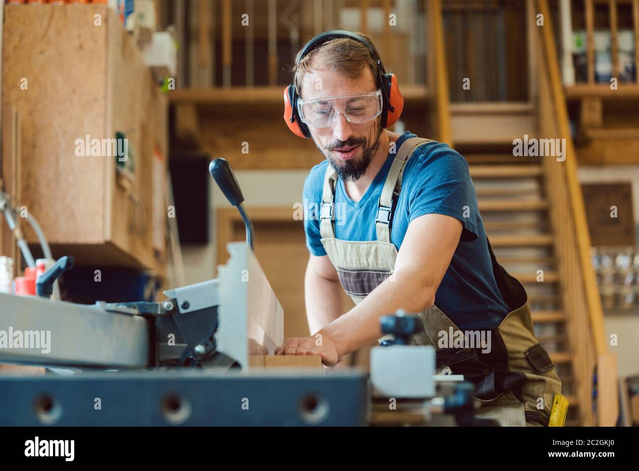 Carpenter working with wood at the circular cutter Stock Photo - Alamy