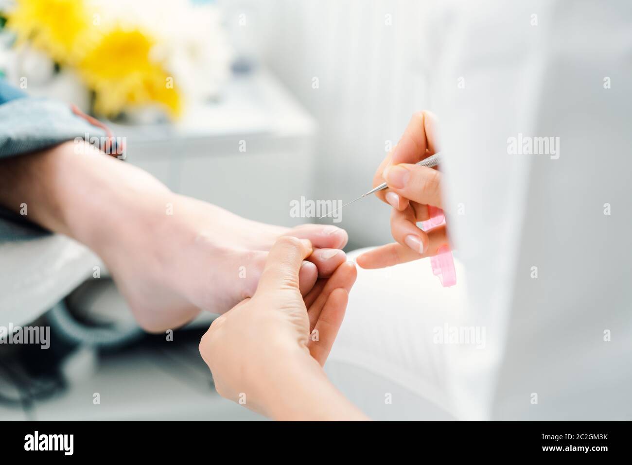 Podiatrist cutting nails on feet of man during pedicure with scissors ...
