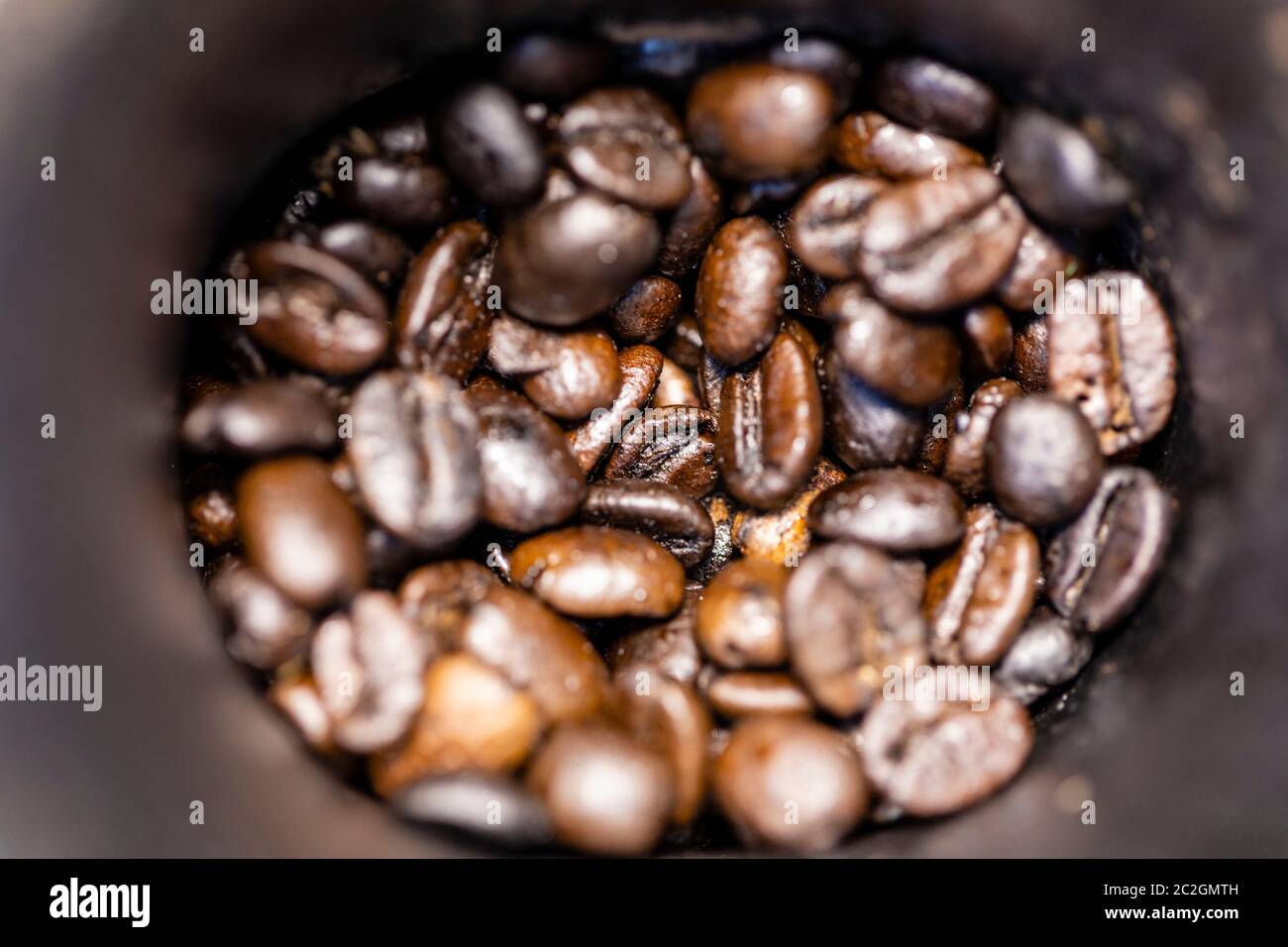 Roasted coffee beans inside in the manual grinder Stock Photo - Alamy