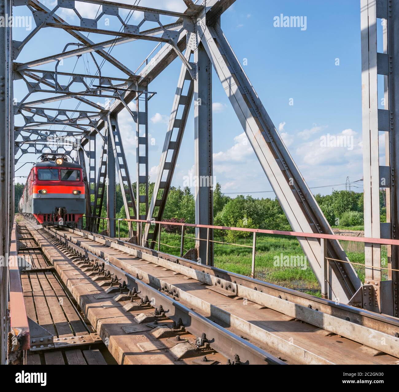 Freight train moves through the bridge above the river Stock Photo - Alamy