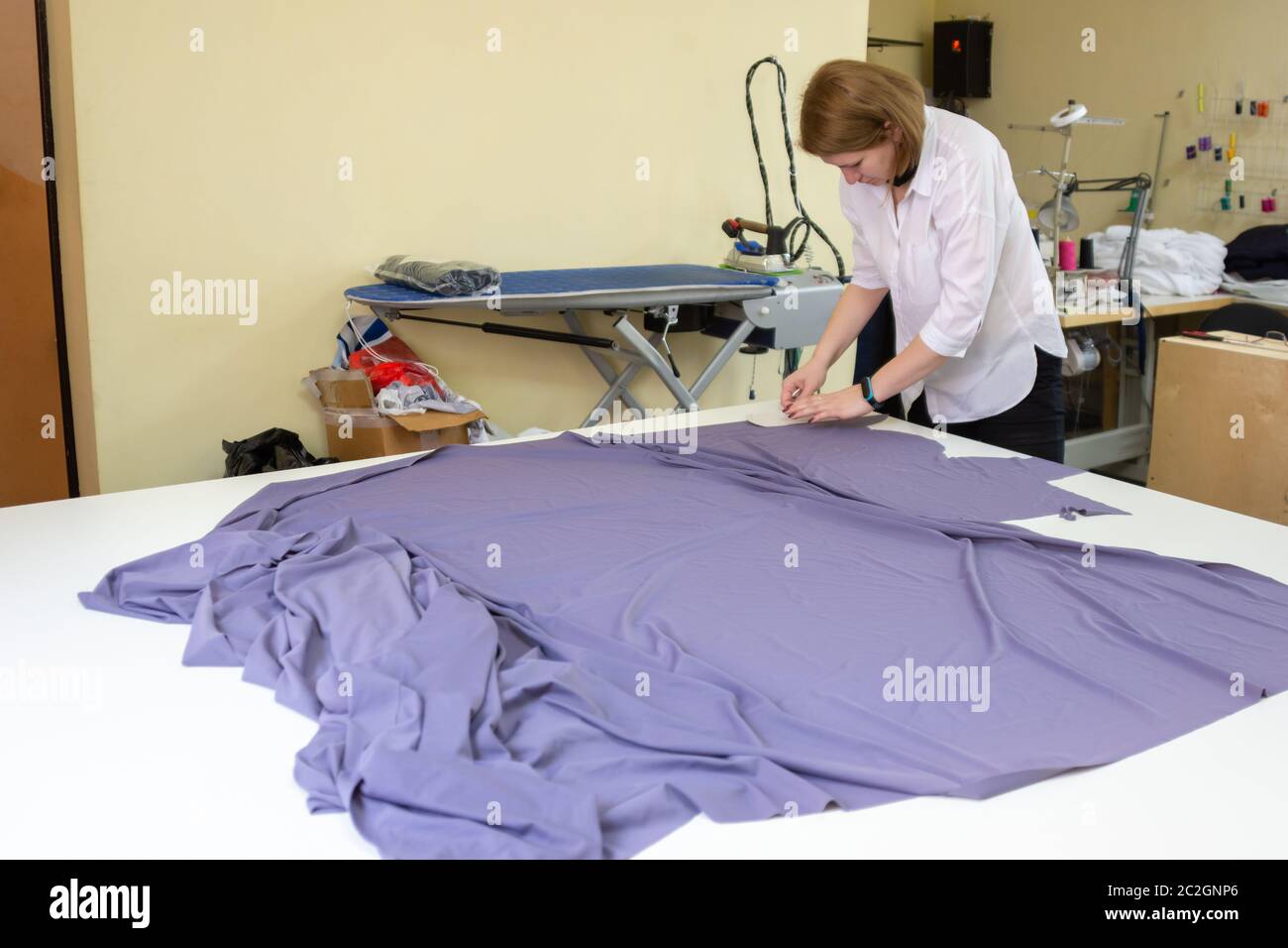 the cutter puts on the material details of clothing on patterns Stock ...