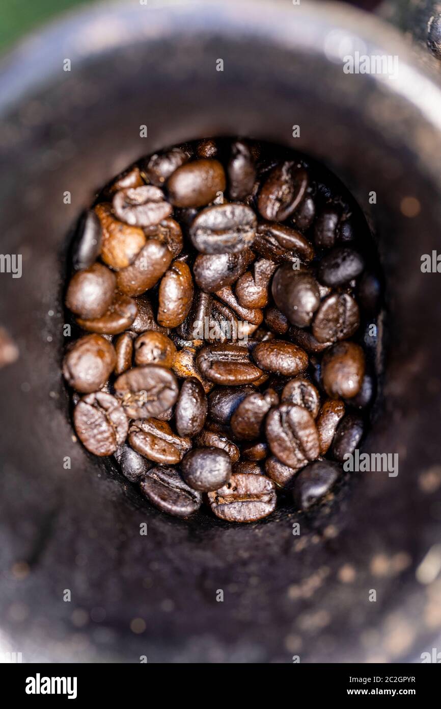 Roasted coffee beans inside in the manual grinder Stock Photo - Alamy