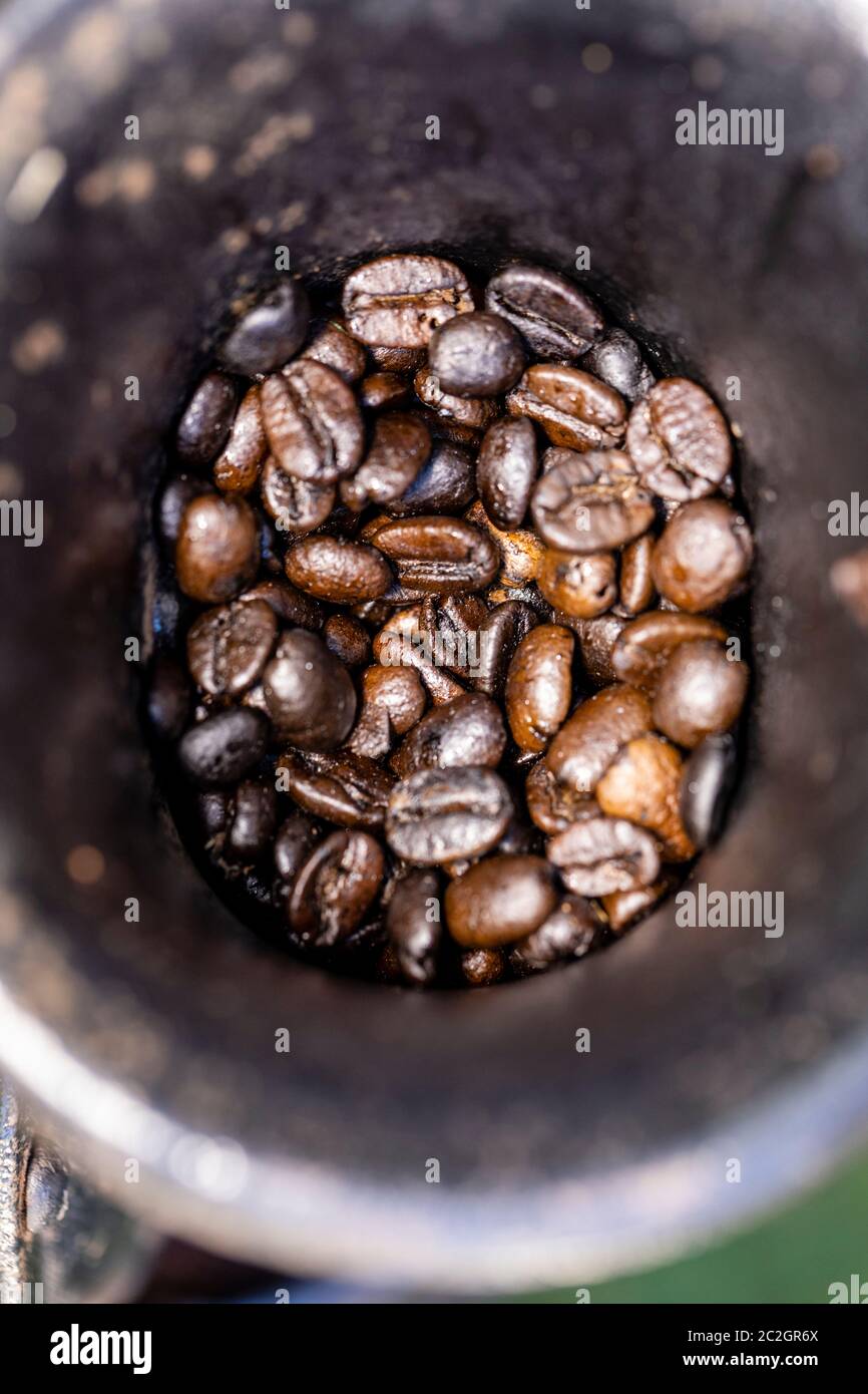 Roasted coffee beans inside in the manual grinder Stock Photo - Alamy