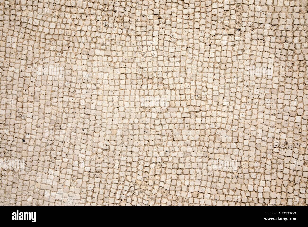 Texture of mosaic stones composed as a white surface of the historical ...