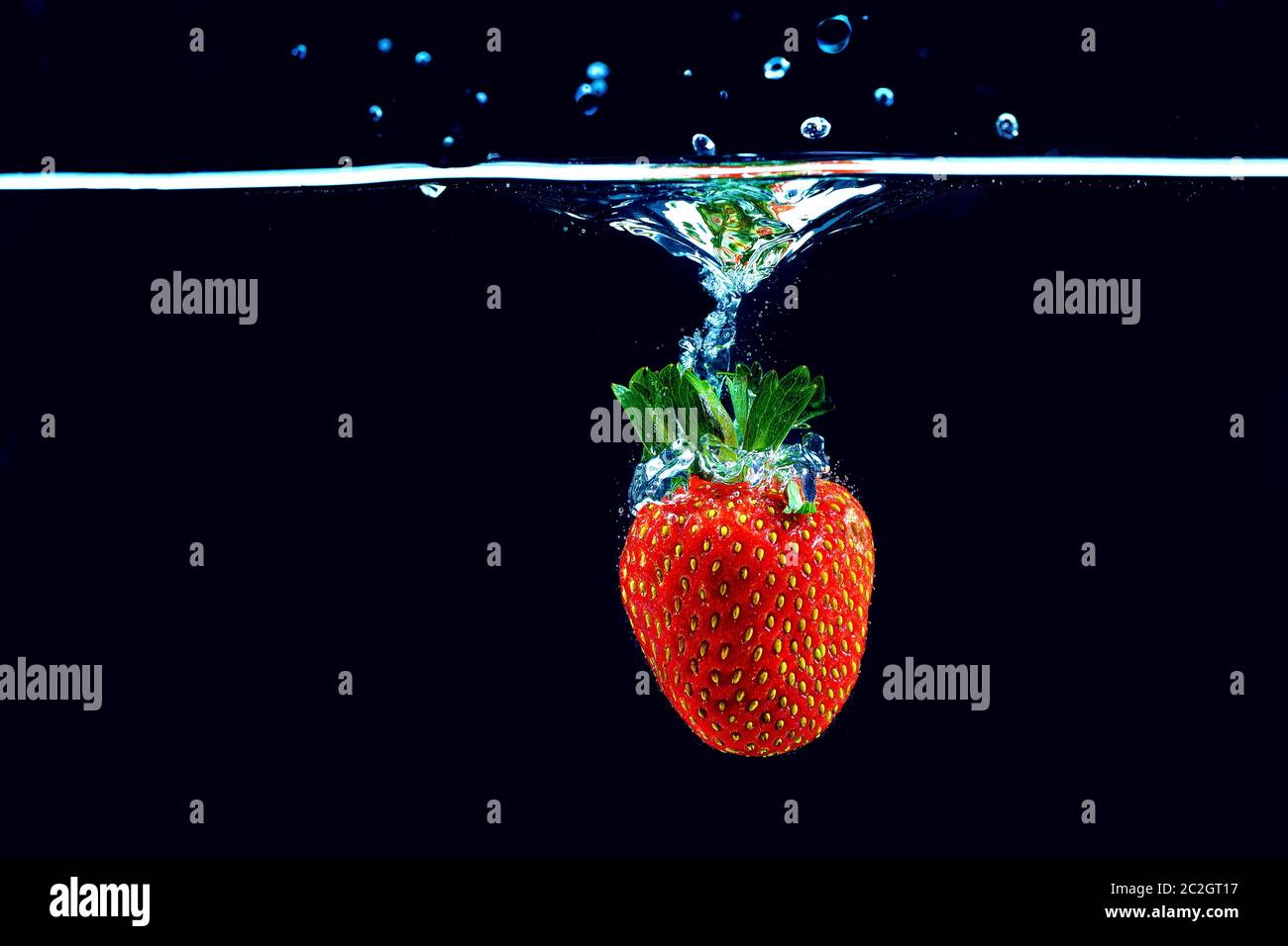 A strawberry splashing into water Stock Photo - Alamy