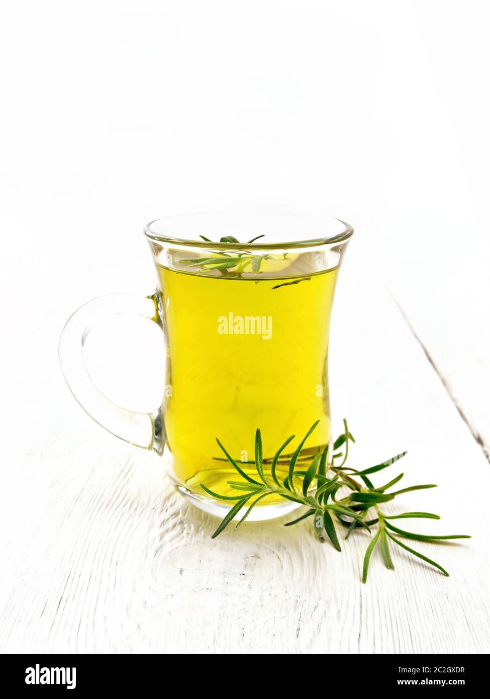 Rosemary herbal tea in a mug on the background of light wooden boards ...