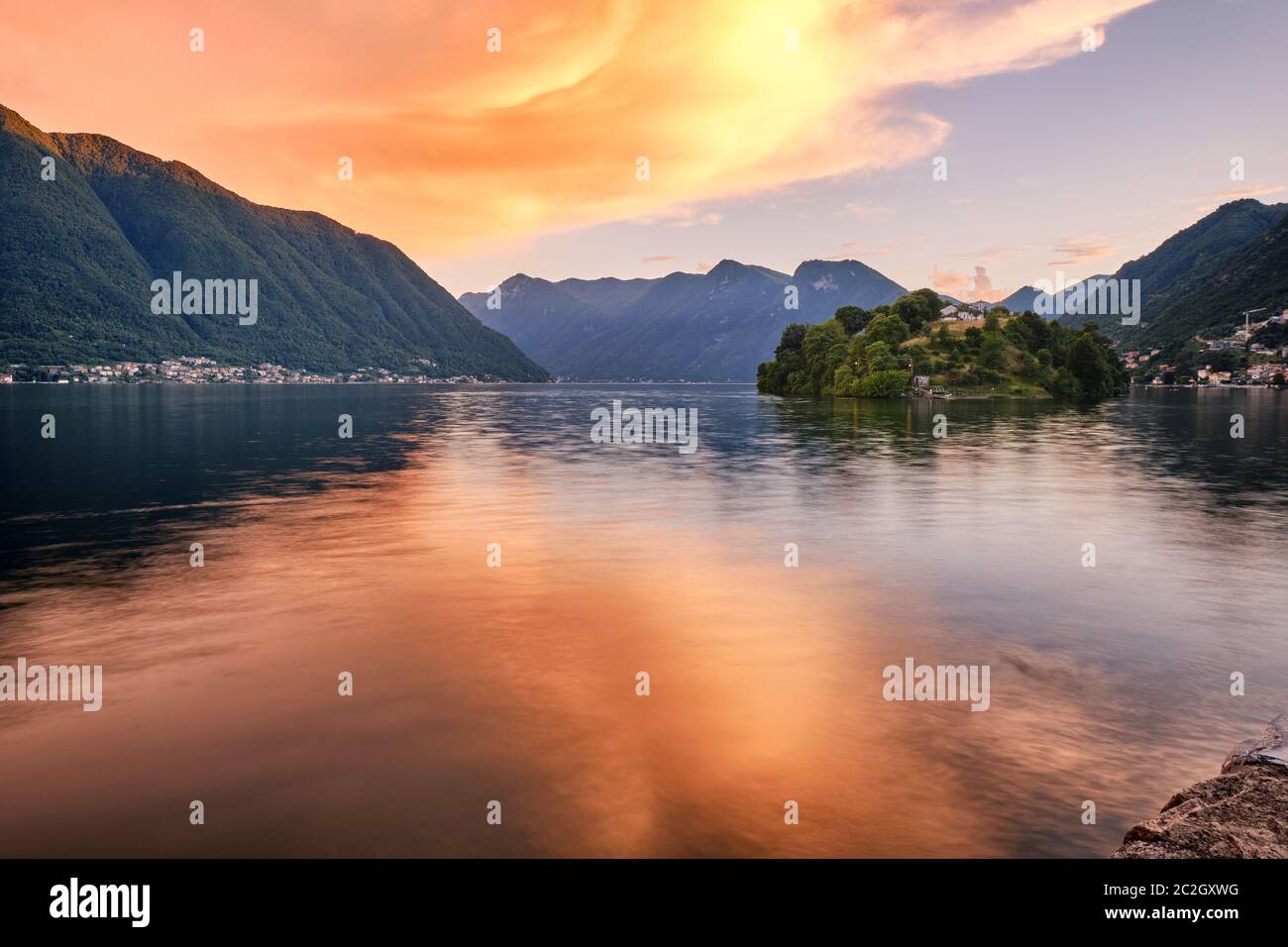 Isola Comacina at sunset surrounded by orange clouds and colourful ...