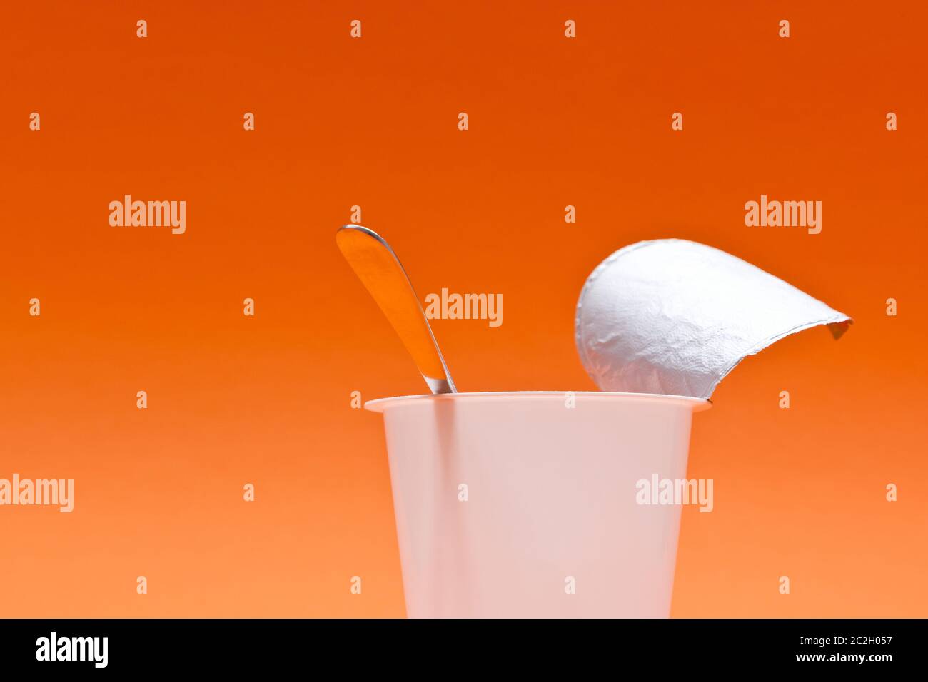 empty clean yogurt cup with spoon on an orange background Stock Photo ...