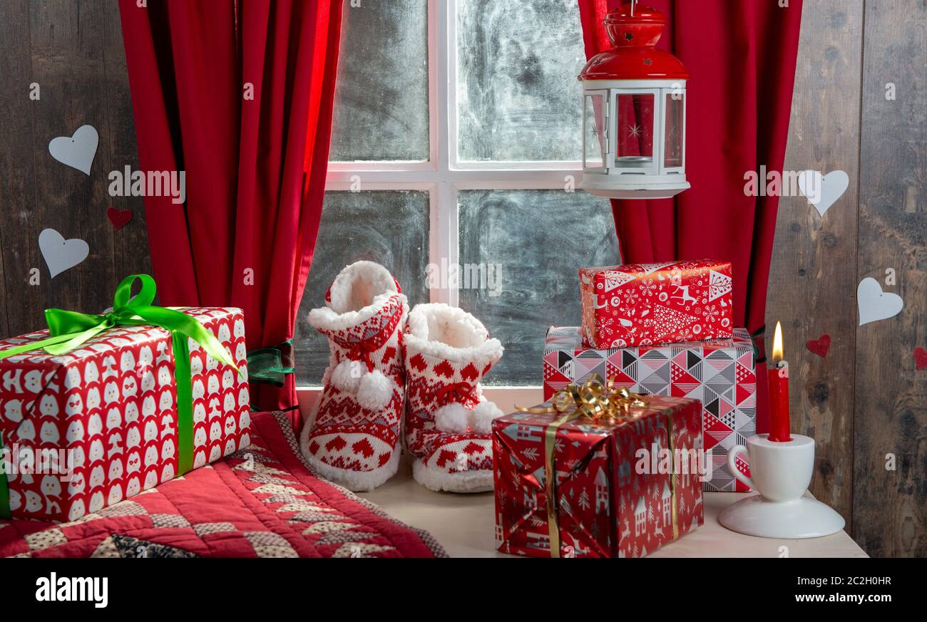 the Christmas gifs decoration near the rustic window Stock Photo - Alamy