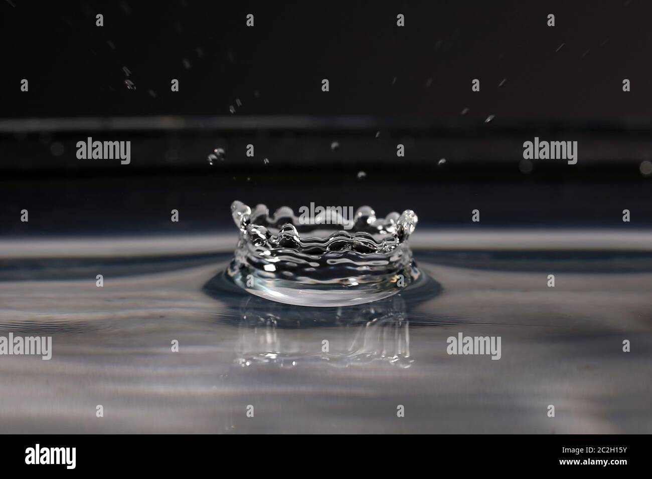A small water drop fall on water surface Stock Photo - Alamy
