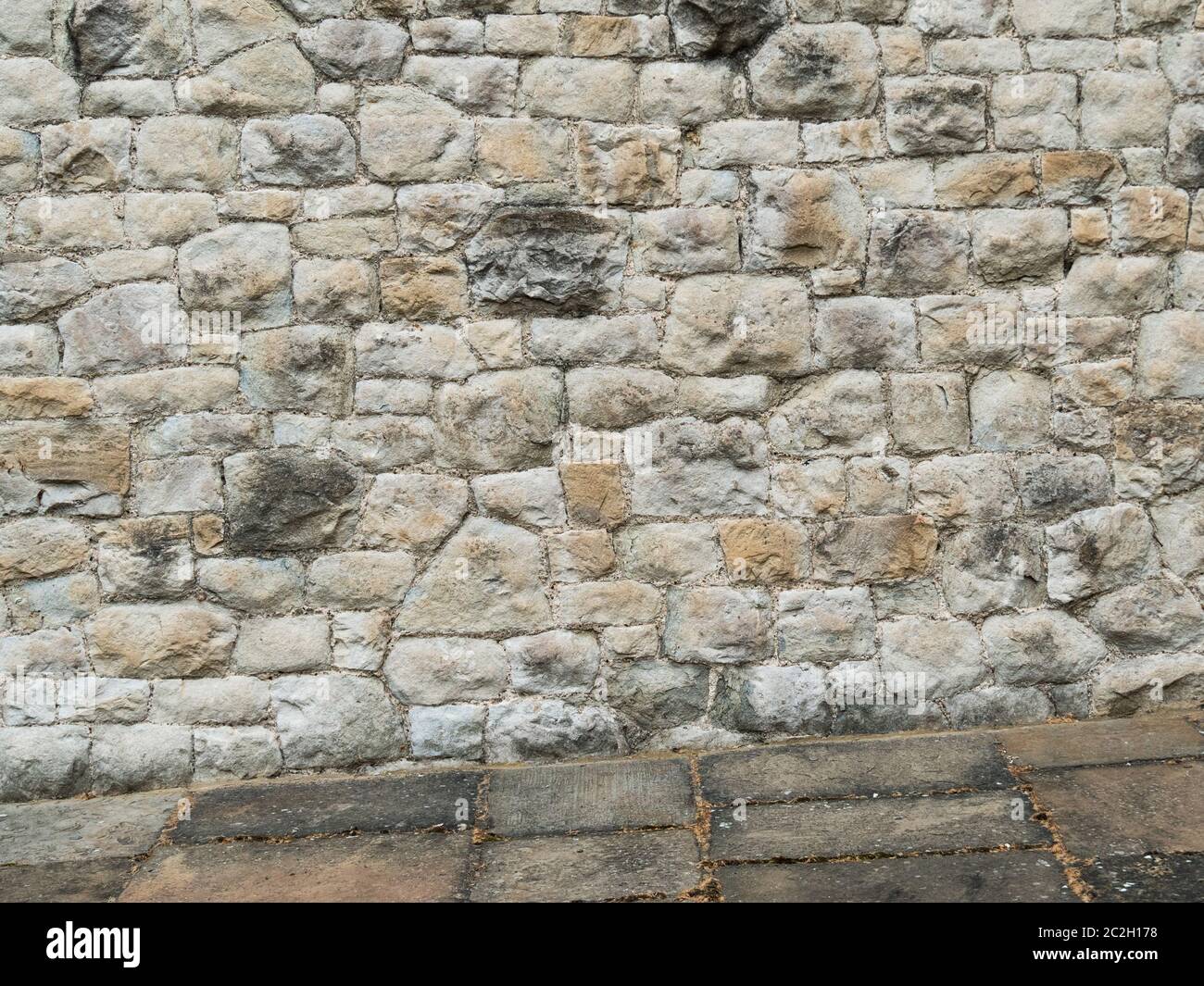 Ancient stone wall paved with cobblestone with stone pavement at an ...