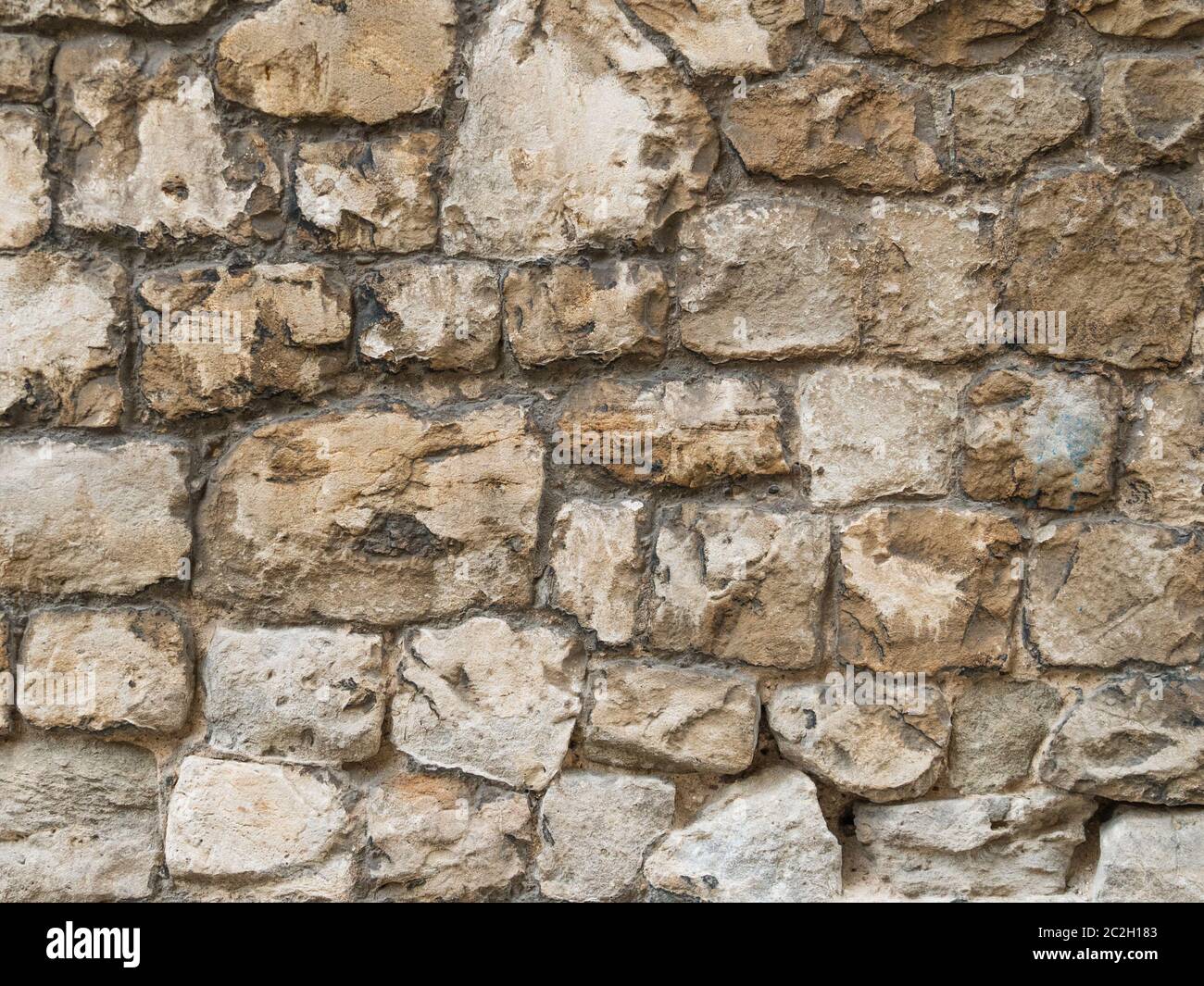 Stone ancient wall paved with cobble stones, closeup. Old stone wall ...