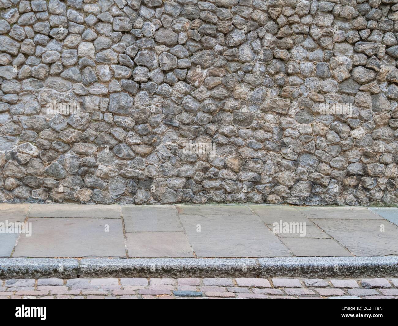 Natural rough stone wall texture background with concrete slabs and a ...