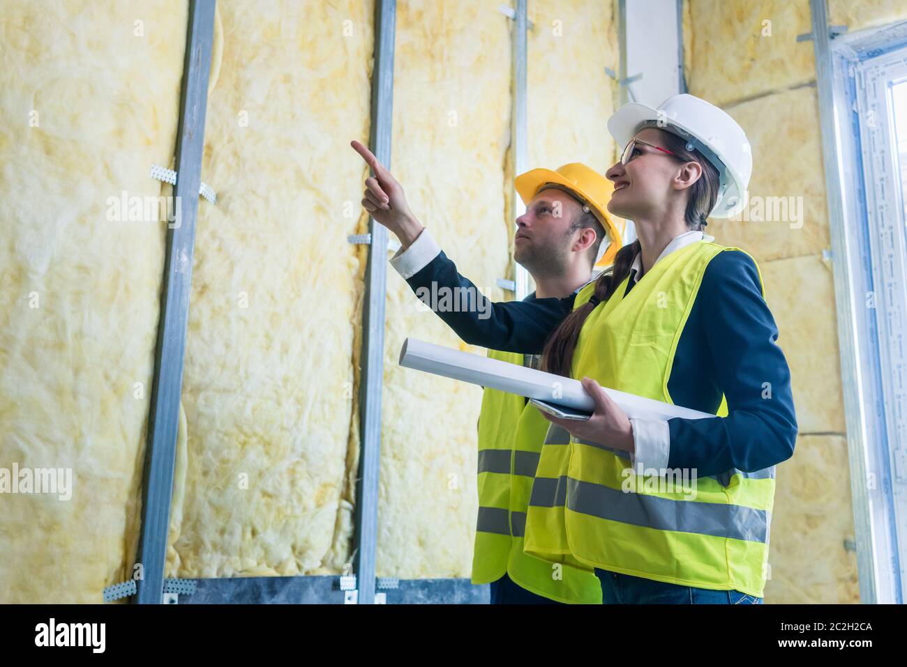 Construction manager and architect checking the insulation works in a ...