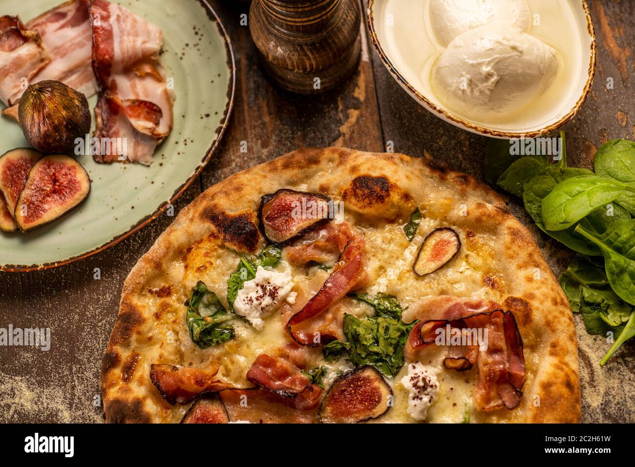 Pizza on a wood table with ingredients Stock Photo - Alamy