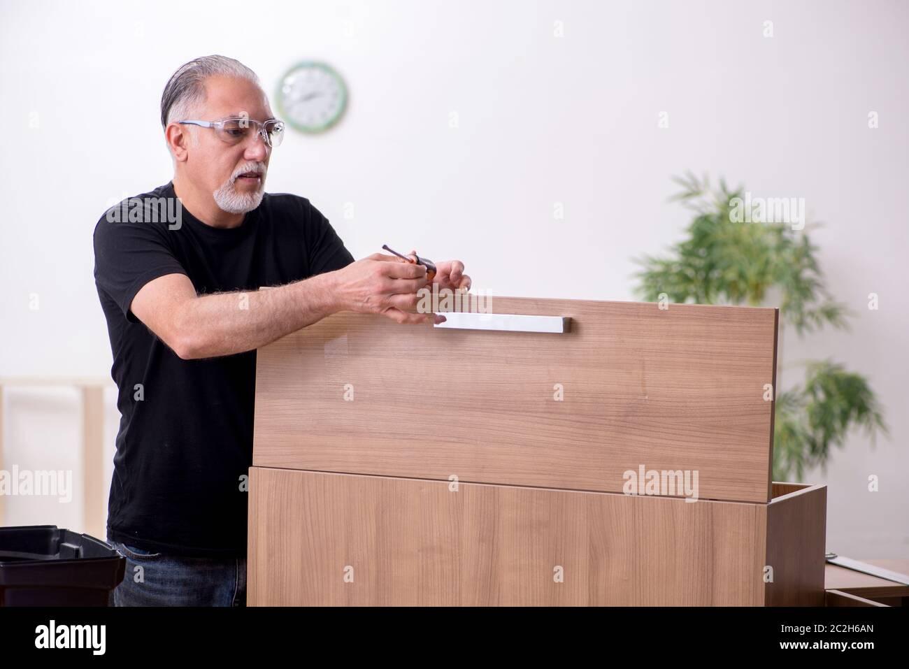 Old carpenter working indoors on furniture Stock Photo - Alamy