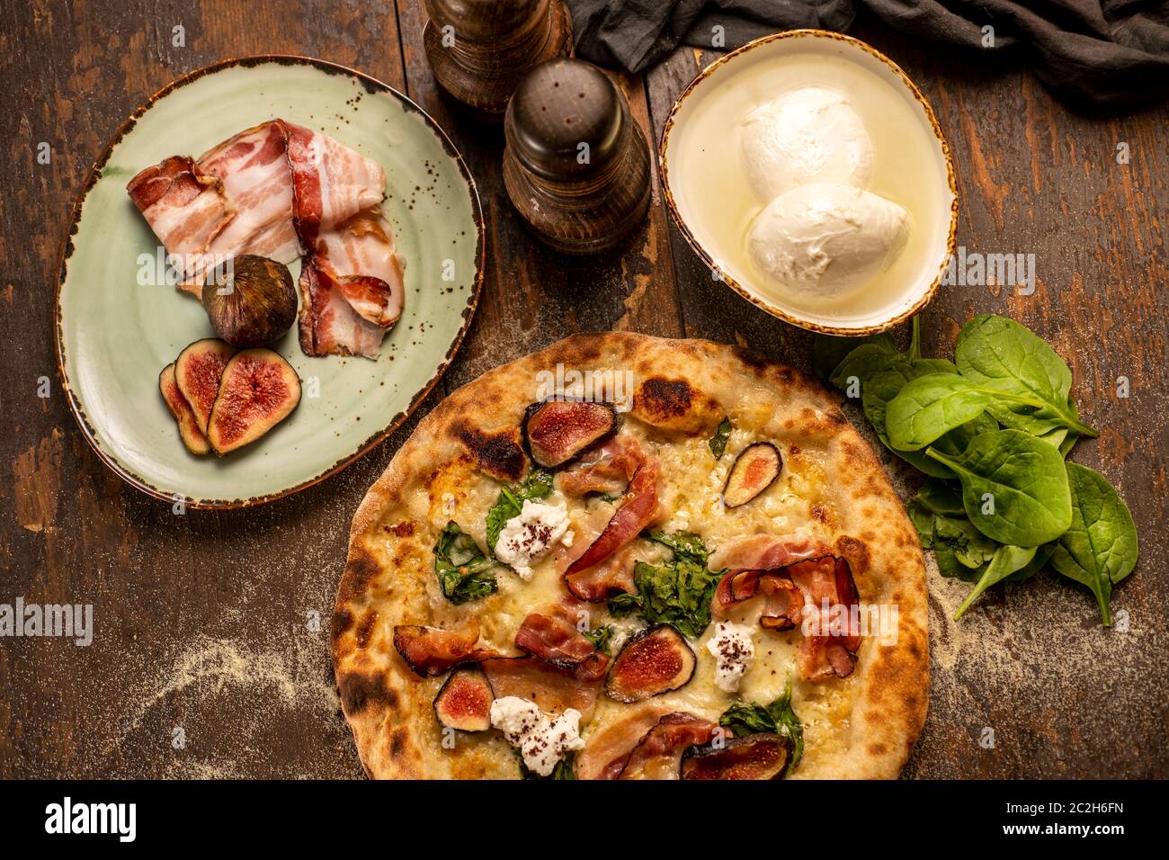 Pizza on a wood table with ingredients Stock Photo - Alamy