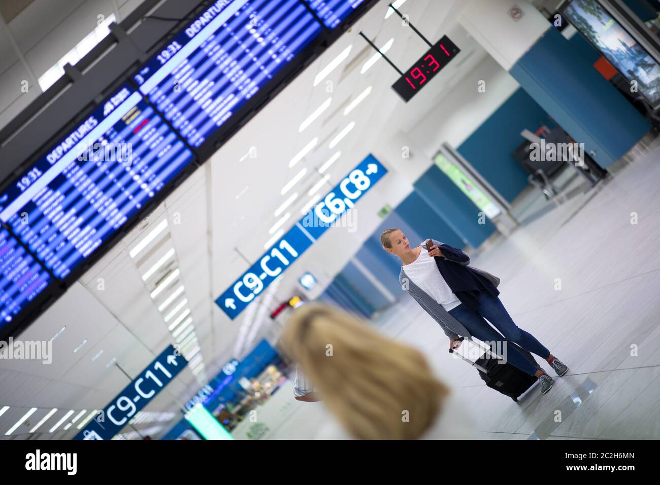 Young woman with her luggage at an international airport, before going ...