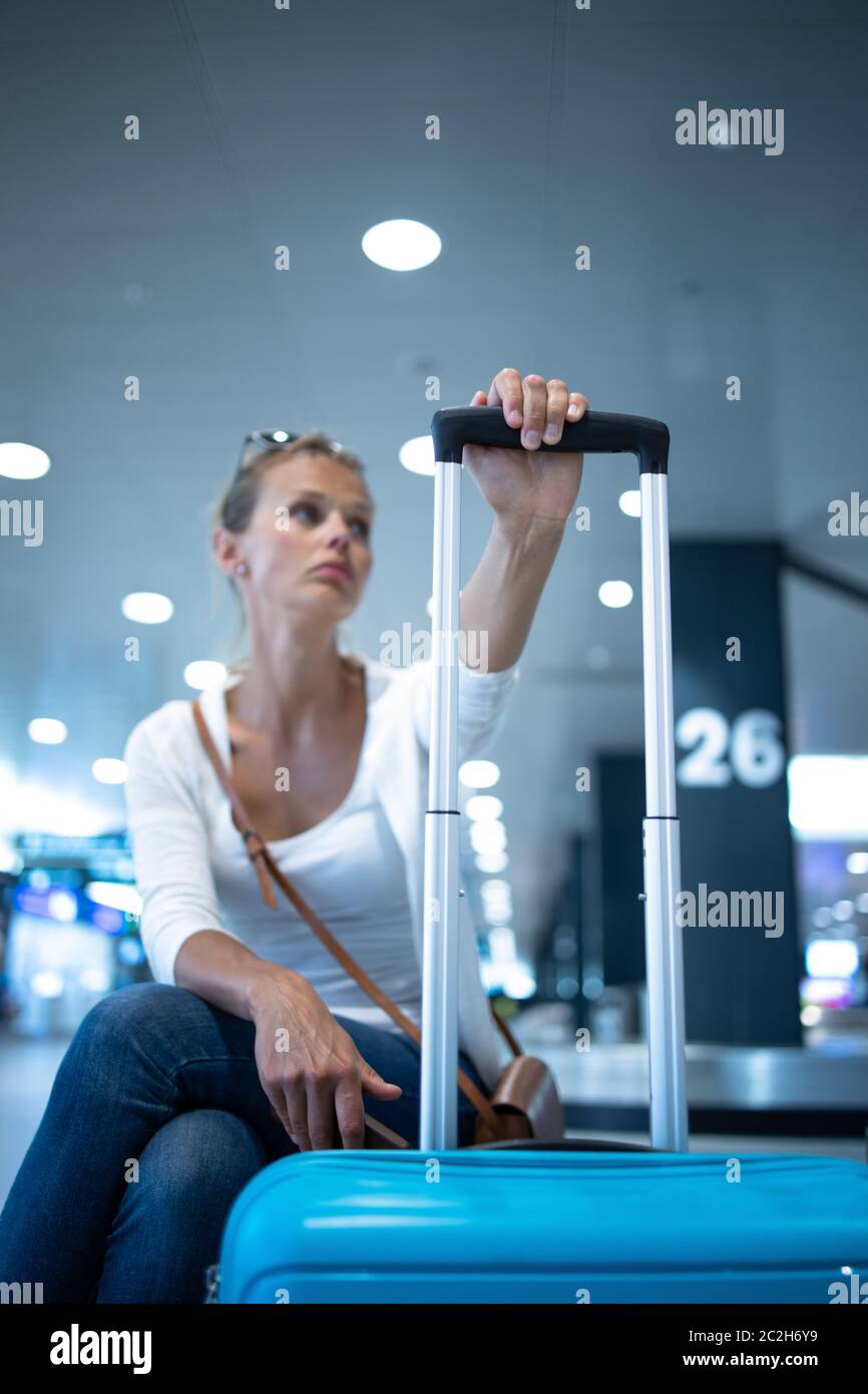 Young woman with her luggage at an international airport, before going ...
