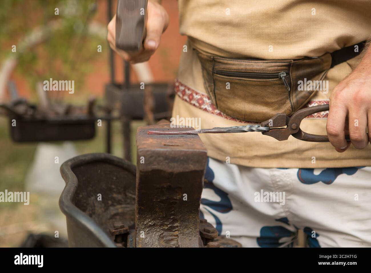 Blacksmith working on metal on an anvil in the forge Stock Photo - Alamy
