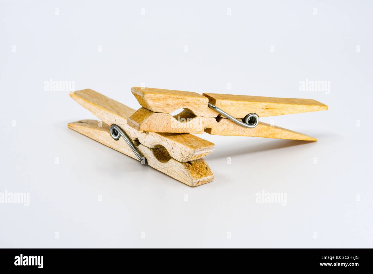 Two traditional wooden clothes pegs isolated on a plain white ...