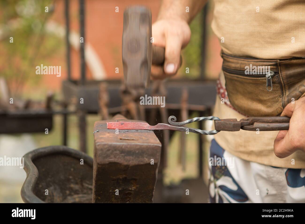 Blacksmith working on metal on an anvil in the forge Stock Photo - Alamy