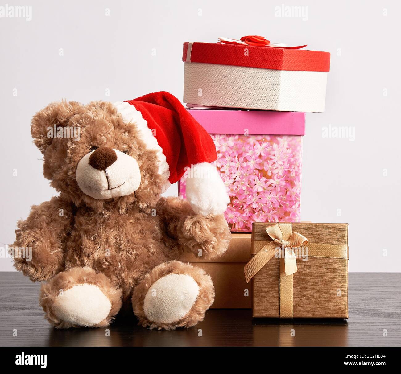brown teddy bear and a stack of various cardboard boxes for gifts on a ...