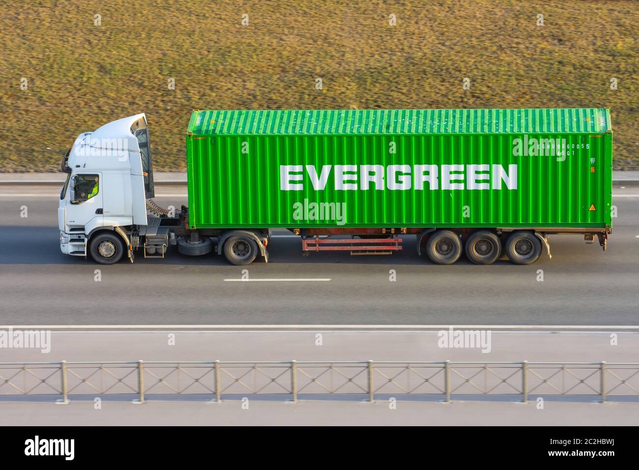 Truck with trailer and green container company Evergreen on city ...