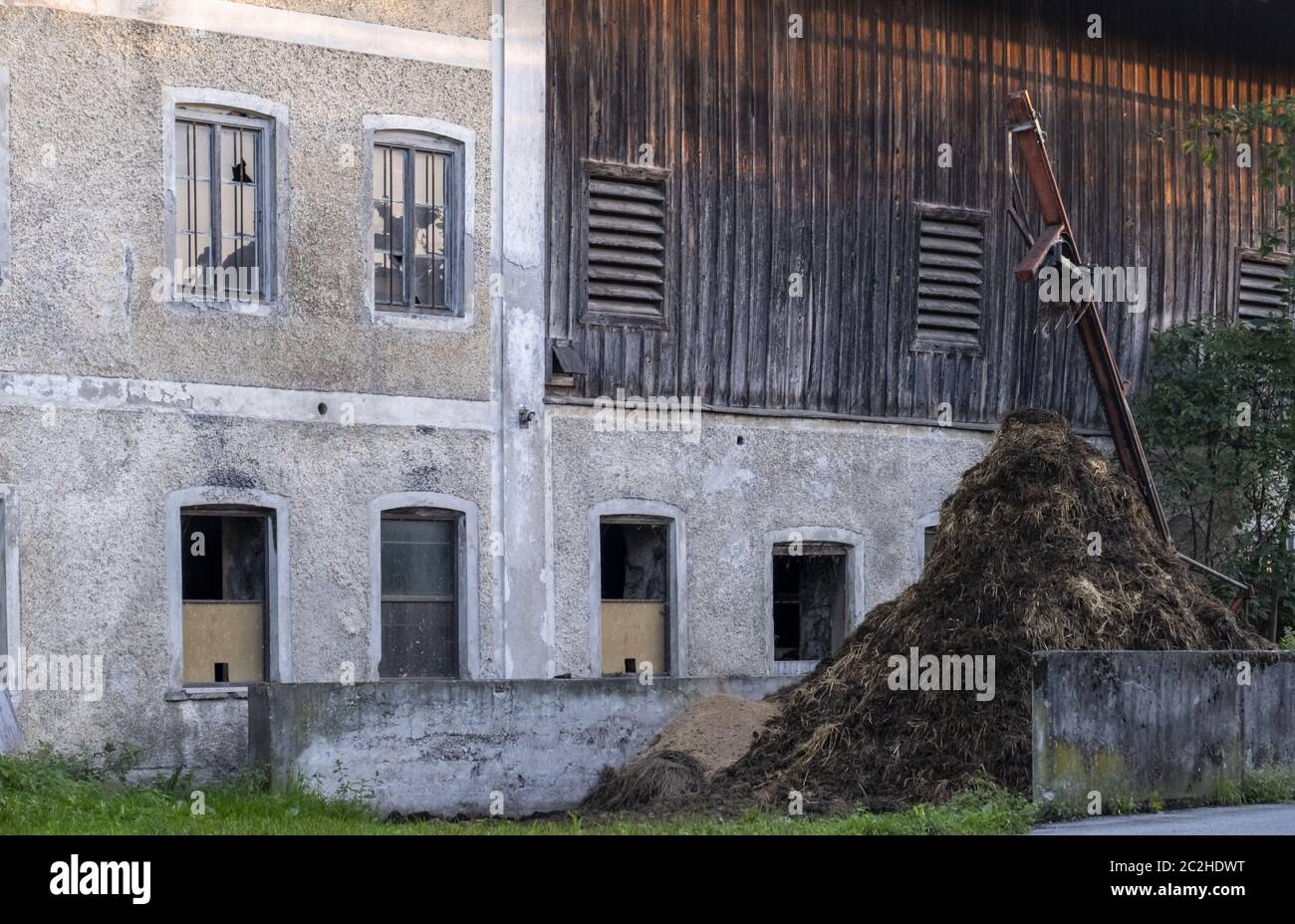 Dung heap in front of old stable building Stock Photo - Alamy