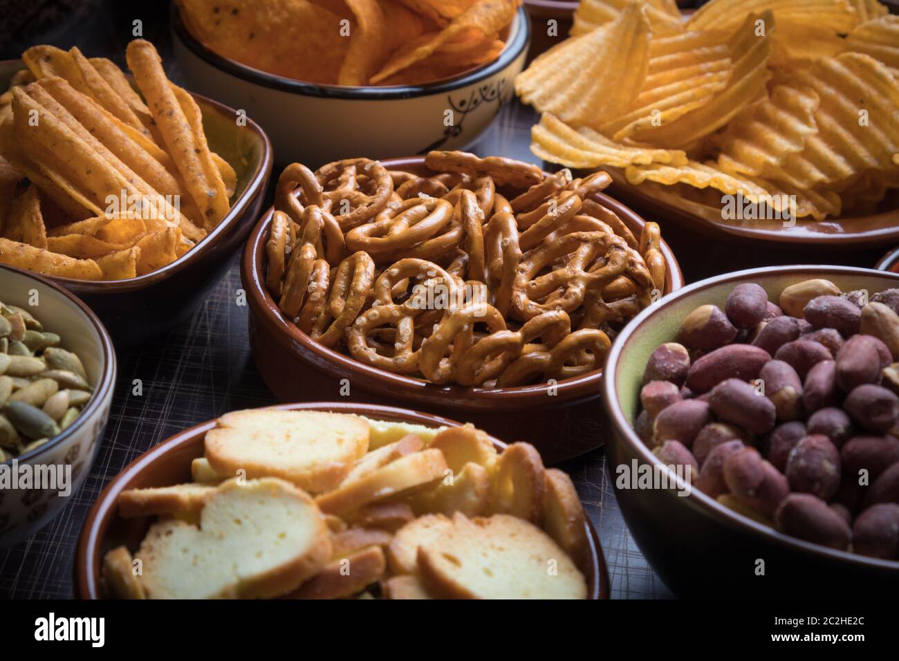 Salty snacks served as party food in ceramic bowls Stock Photo - Alamy