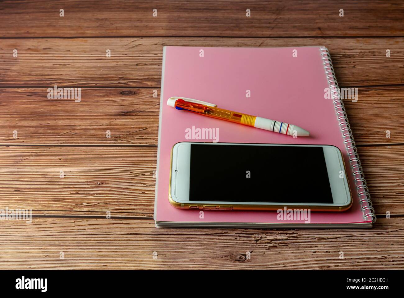 Smart phone mobile with notebook on blurred wooden background, Write ...
