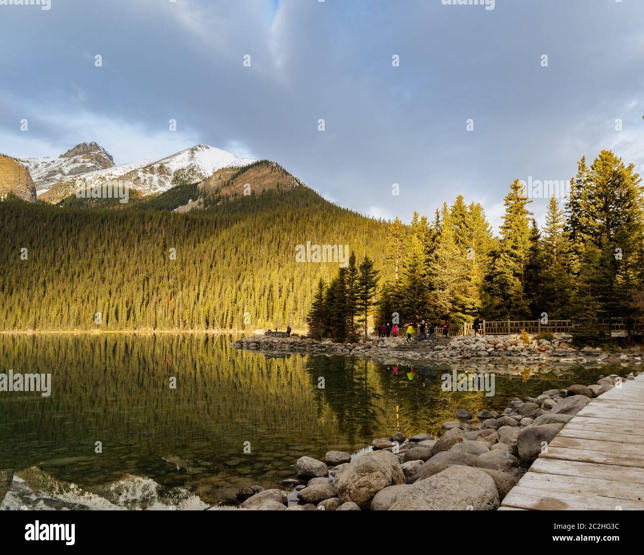 Morning sunshine view of Lake Louise with pine forest in Banff National ...