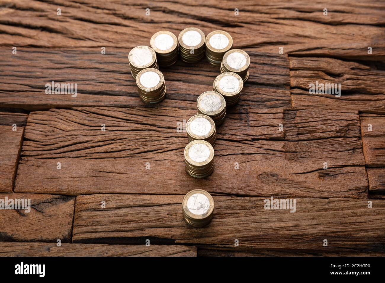 Stacked Coins Forming Question Mark On Wooden Desk Stock Photo - Alamy