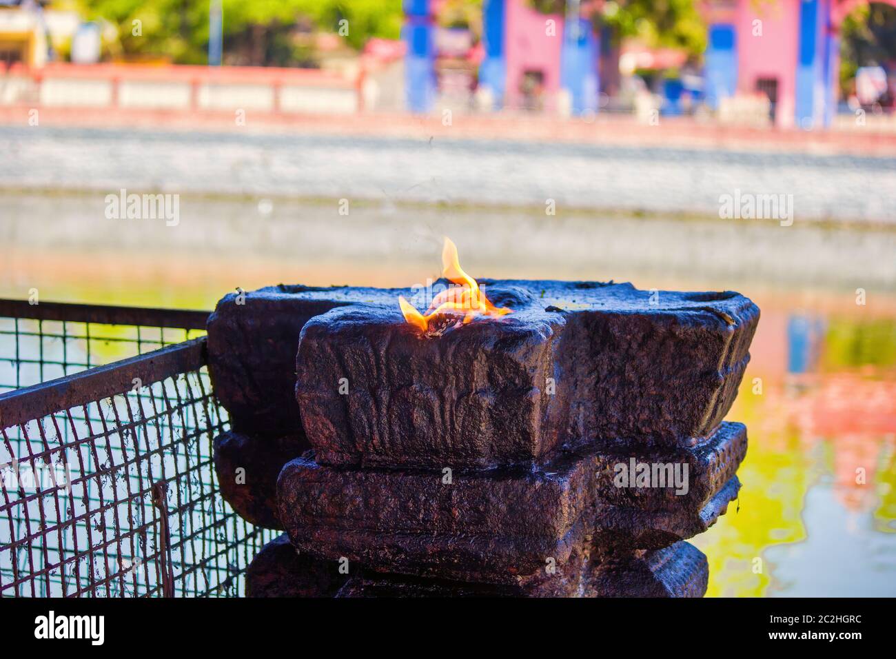A fire on a permanent stone in a hindu temple entrance in India Stock ...
