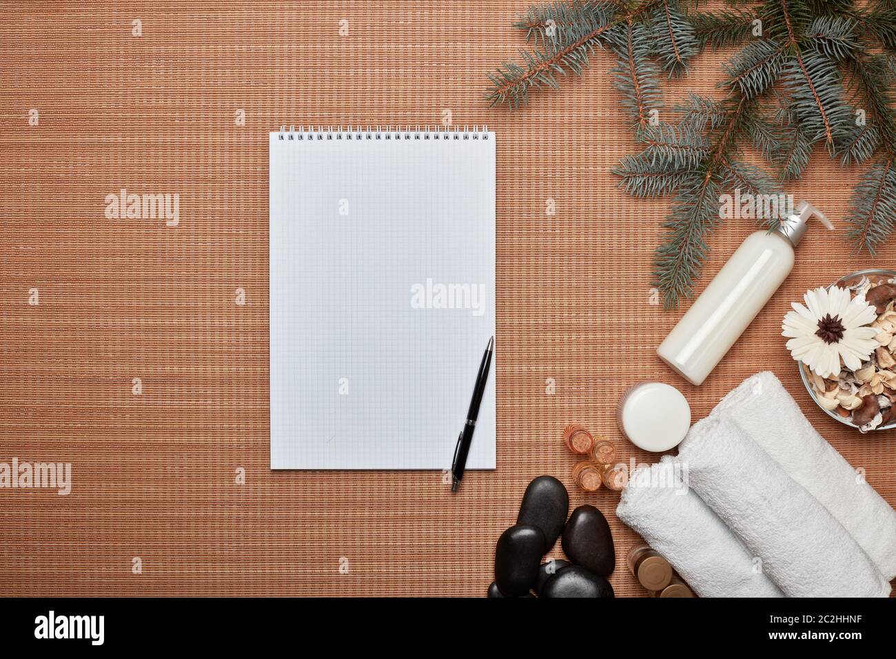 Spa composition, blank sheet in notebook and fir branch on bamboo mat ...