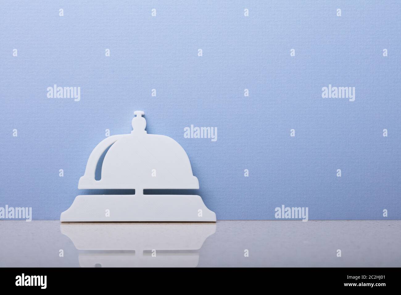 Close-up Of A Concierge Bell Symbol Leaning On Blue Wall Stock Photo ...