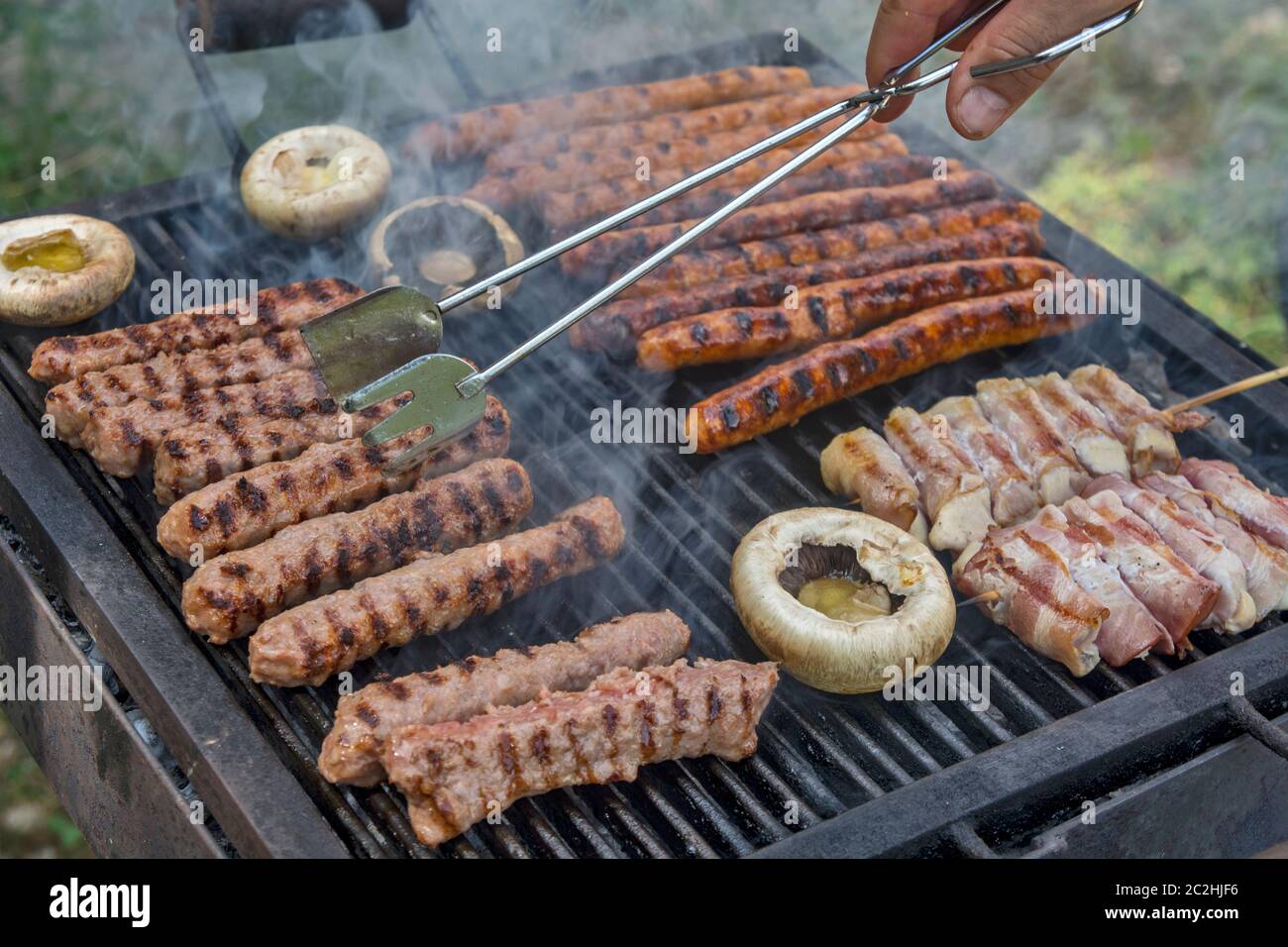 Preparing barbecue meat at picnic in nature. The meat is roasted in a ...