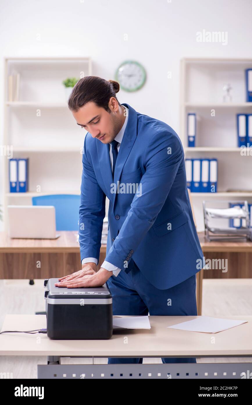 Young employee making copies at copying machine Stock Photo - Alamy