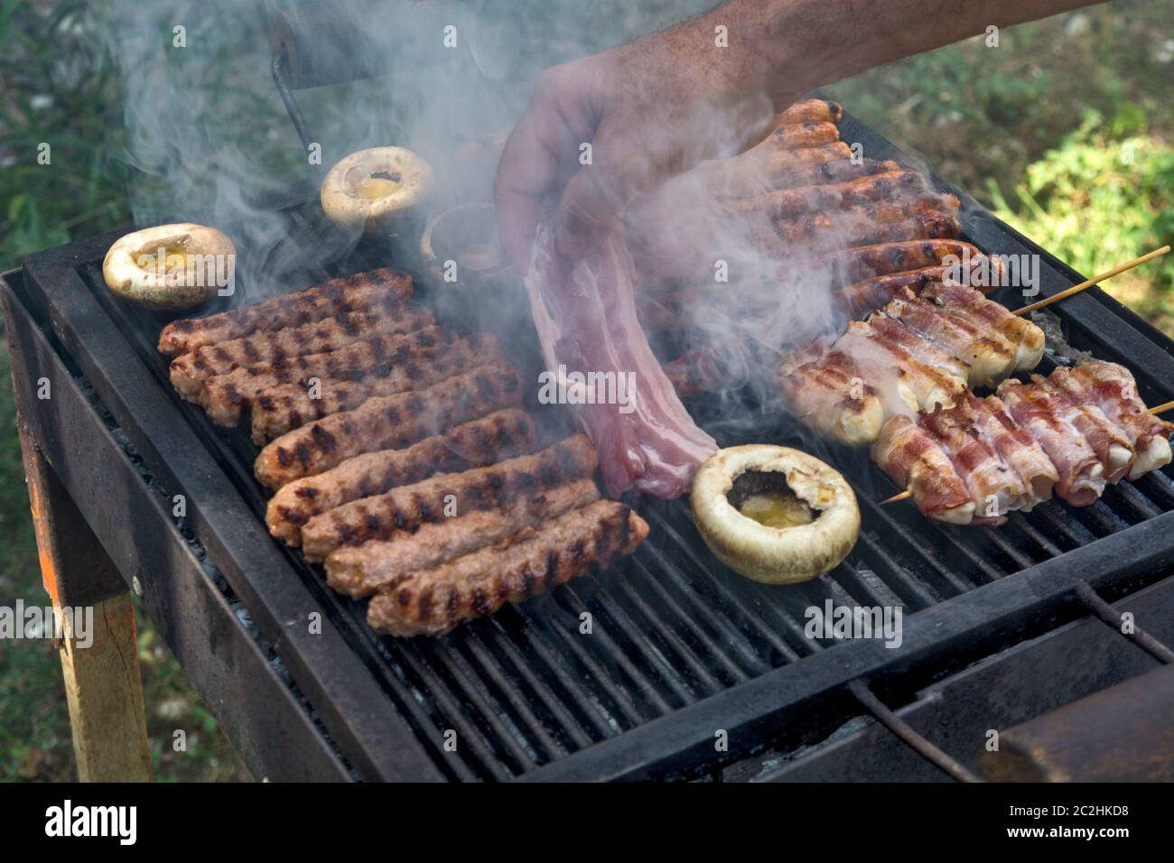 Preparing barbecue meat at picnic in nature. The meat is roasted in a ...